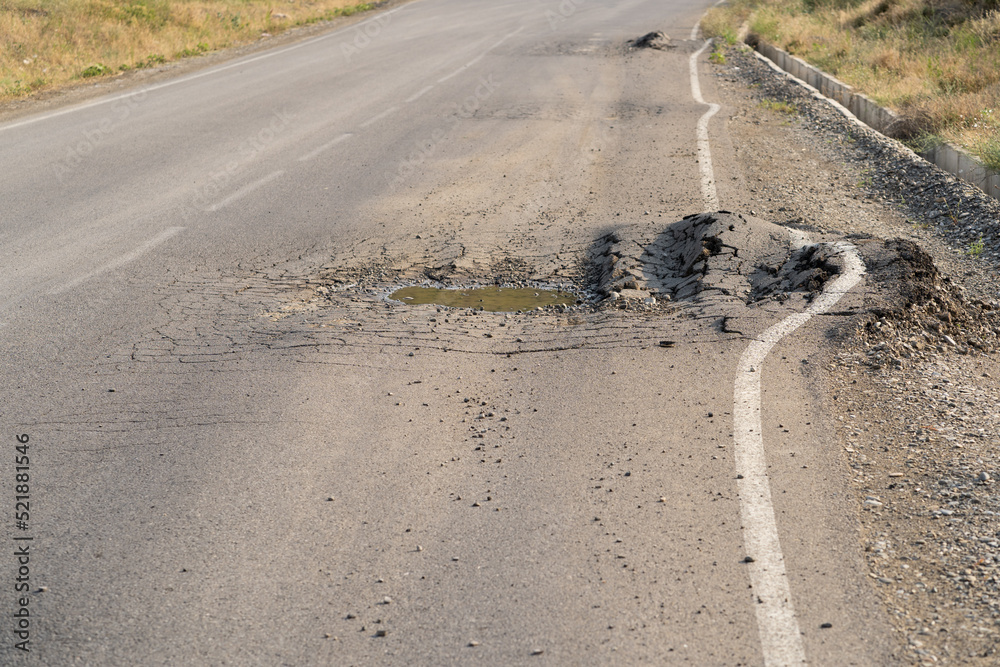 Foto de Deep hole in the road. Deformed asphalt surface with potholes ...