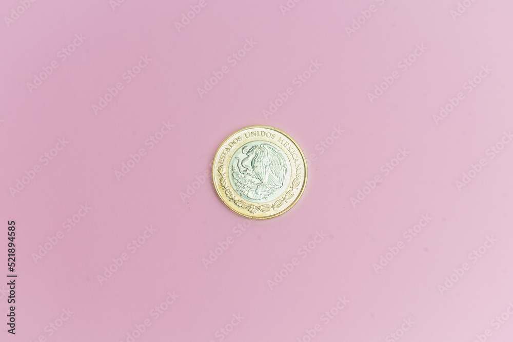 Moneda de 10 pesos mexicanos sobre fondo rosa. Stock Photo | Adobe Stock
