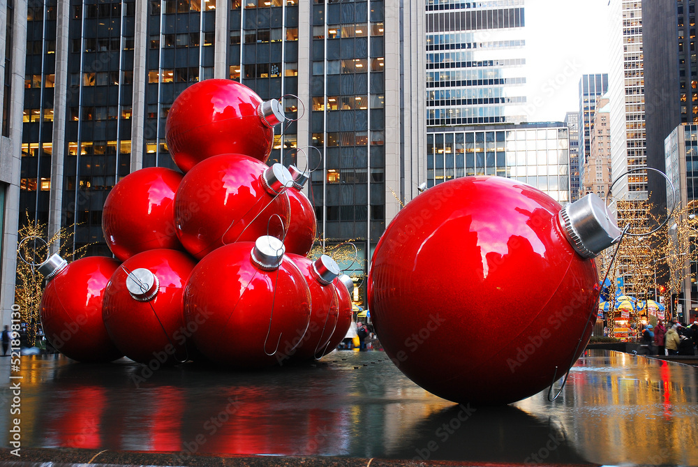 Large Christmas balls sit in a fountain in a plaza during the holiday ...