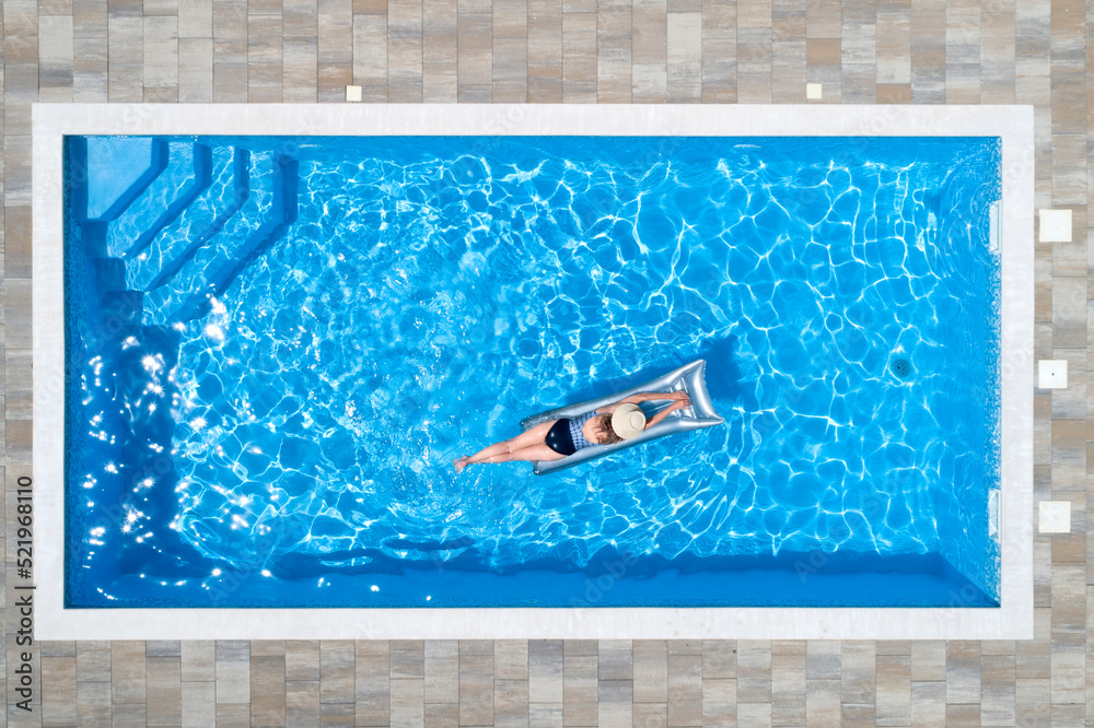 Woman lying on raft in swimming pool Stock Photo | Adobe Stock