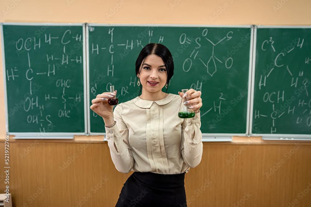 brunette girl conducts a master class in chemistry with flasks in a ...