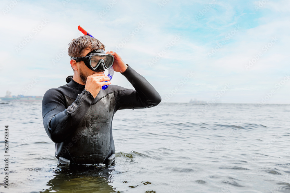 Portrait of a male diver in a wetsuit and diving mask. Freediving ...