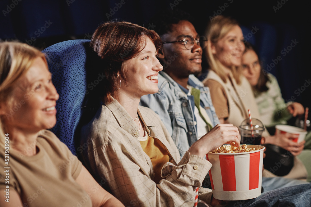 Selective focus of diverse group of people having fun watching film and ...