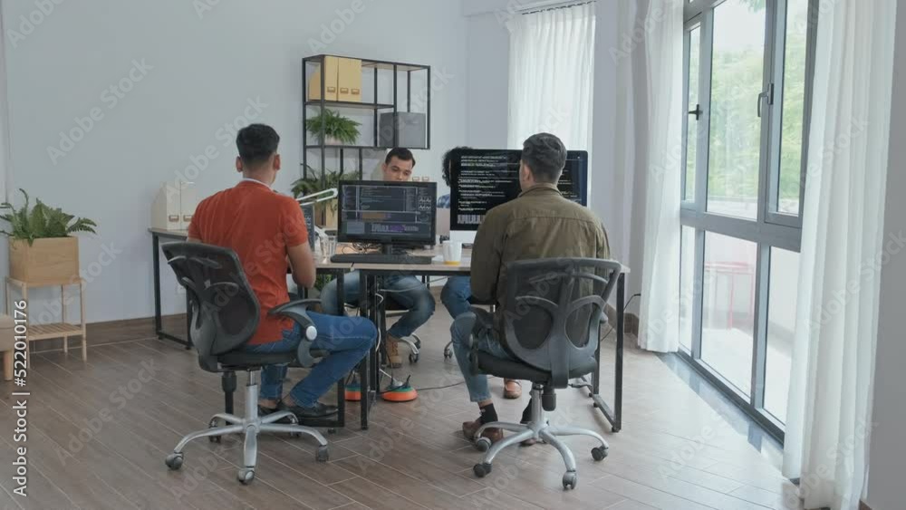 Slowmo of team of Indian programmers sitting by their computers at ...