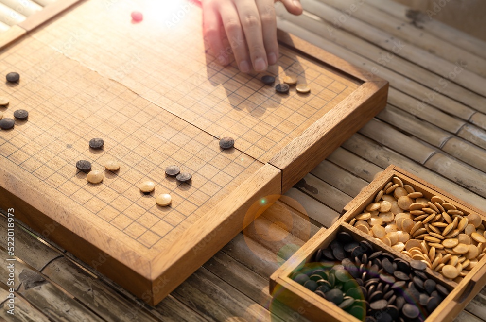 go player hand showing how to hold and place the piece on board. female ...