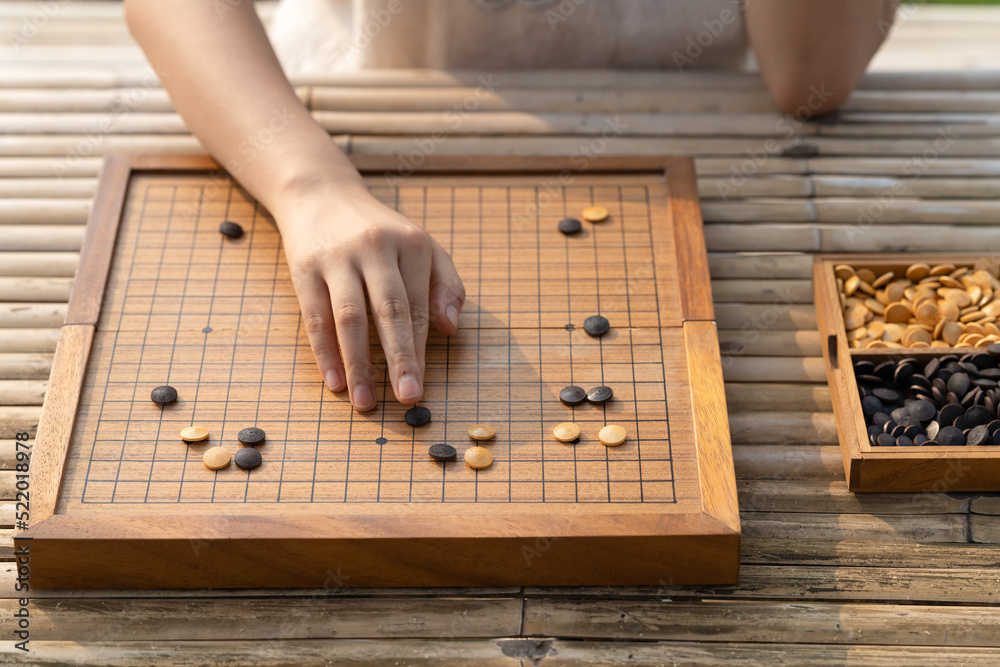 go player hand showing how to hold and place the piece on board. female ...