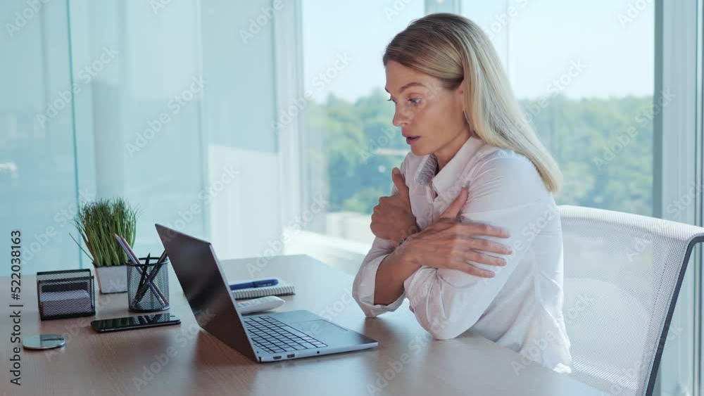 Confident employee woman feeling cold working with laptop rubs with ...