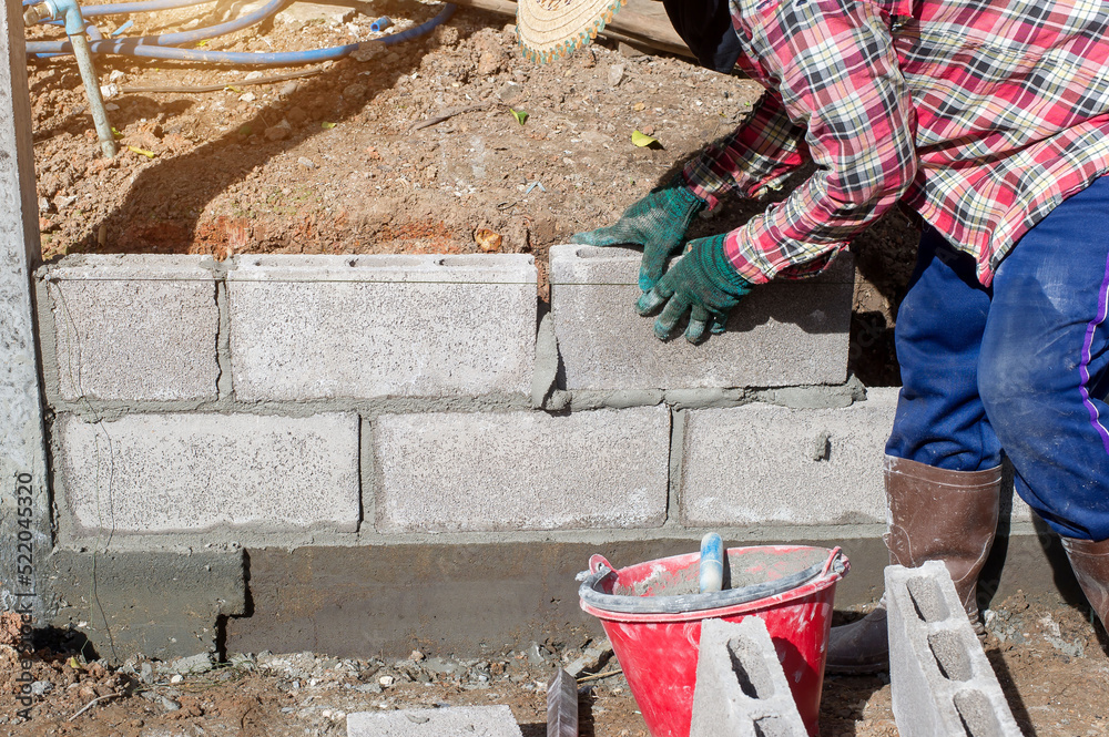 masonry worker make concrete wall by cement block and plaster at ...