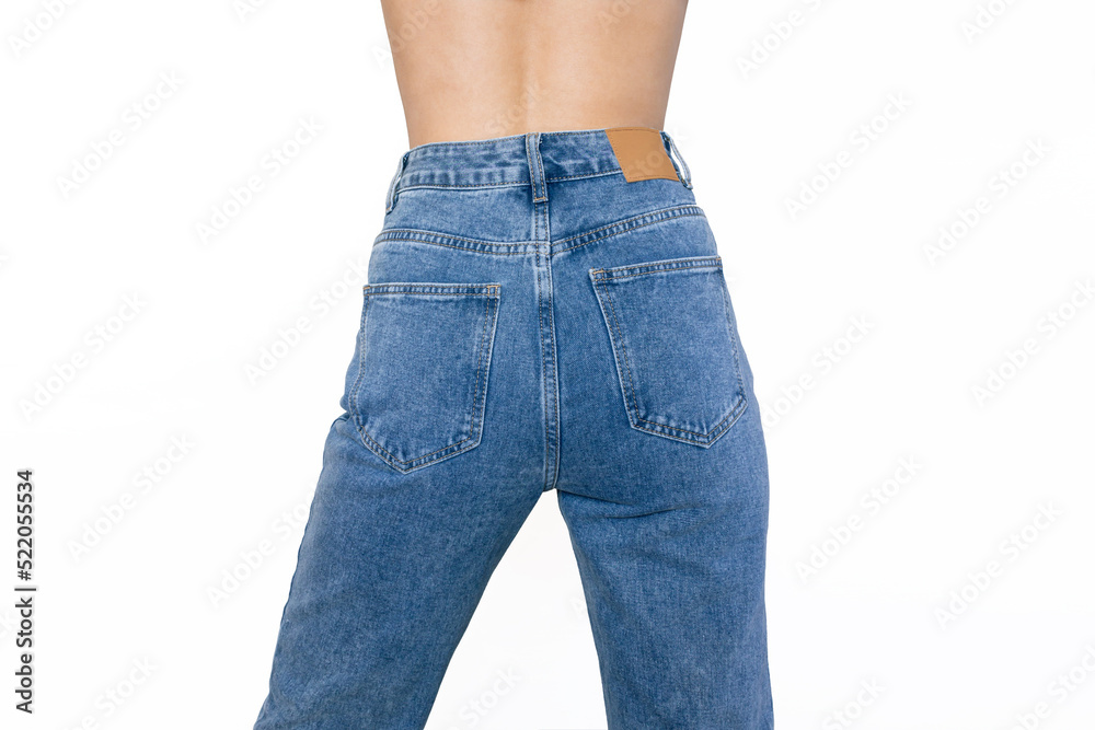 Stylish blue jeans with a high fit on a slender young woman standing ...