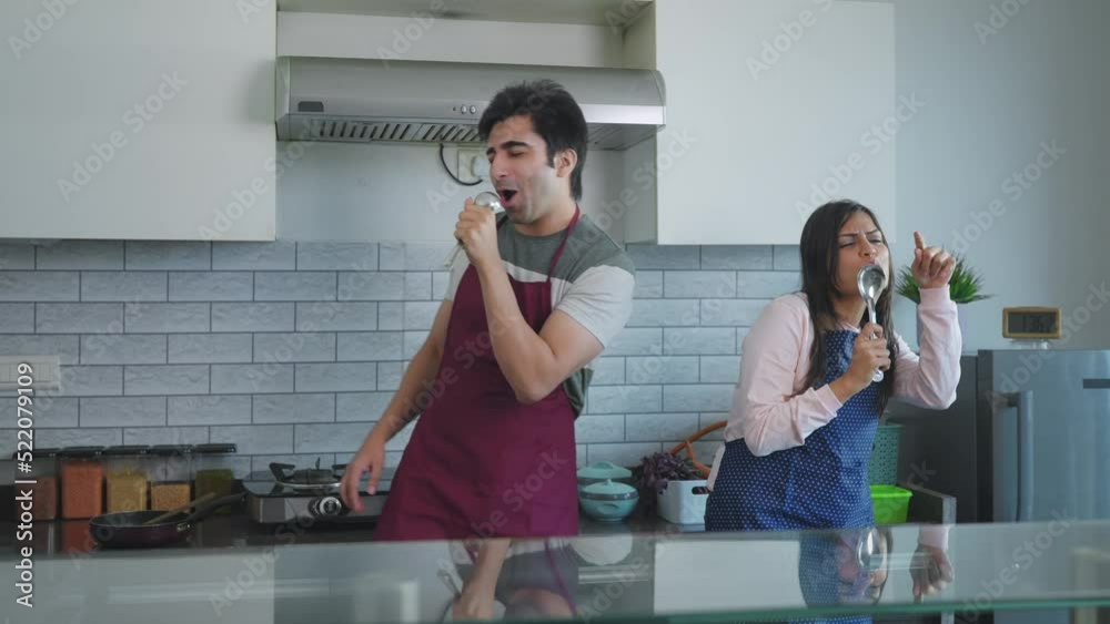 Young happy Indian Asian husband and wife wearing a Chef Apron both ...