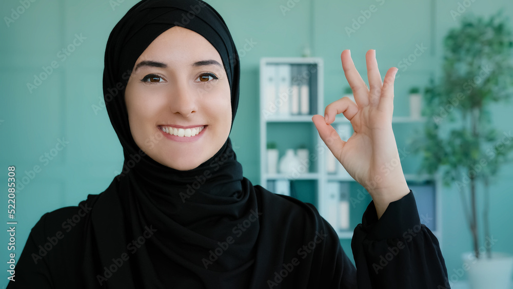 Foto de Portrait indoors Muslim Islamic girl smiles toothy wide at ...