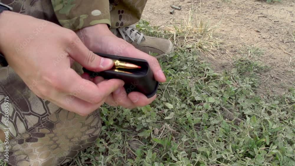 Preparation of Small Arms Ammunition. Hands of a man in camouflage ...