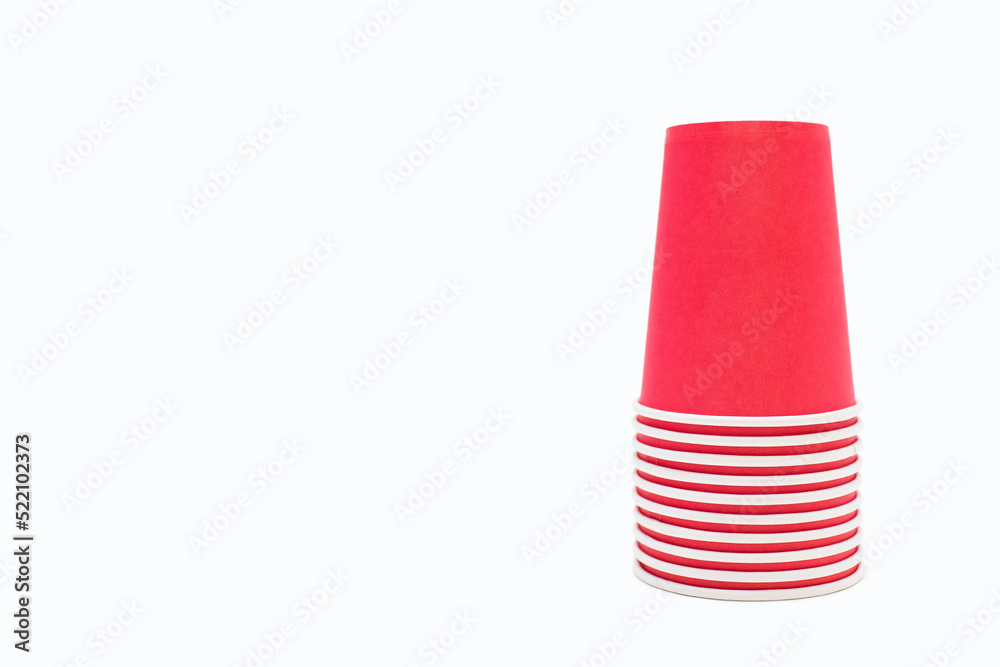 Red disposable cardboard cups stacked in a pile on a white background ...