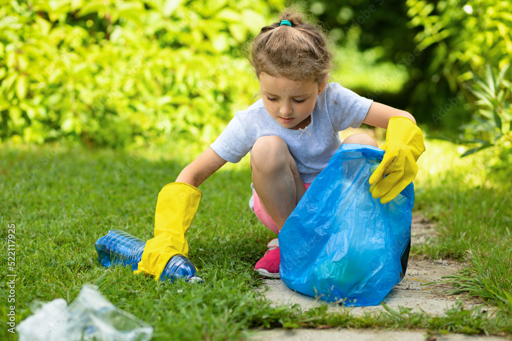 Girl collection plastic garbage in nature. kid picking up trash in park ...