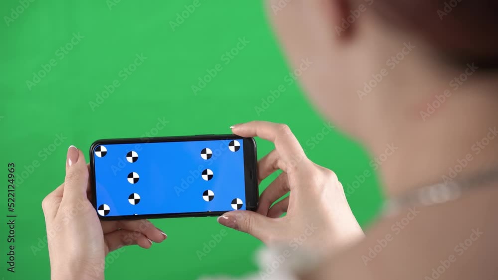 Caucasian woman holds the phone horizontally in her hands and swiped up ...