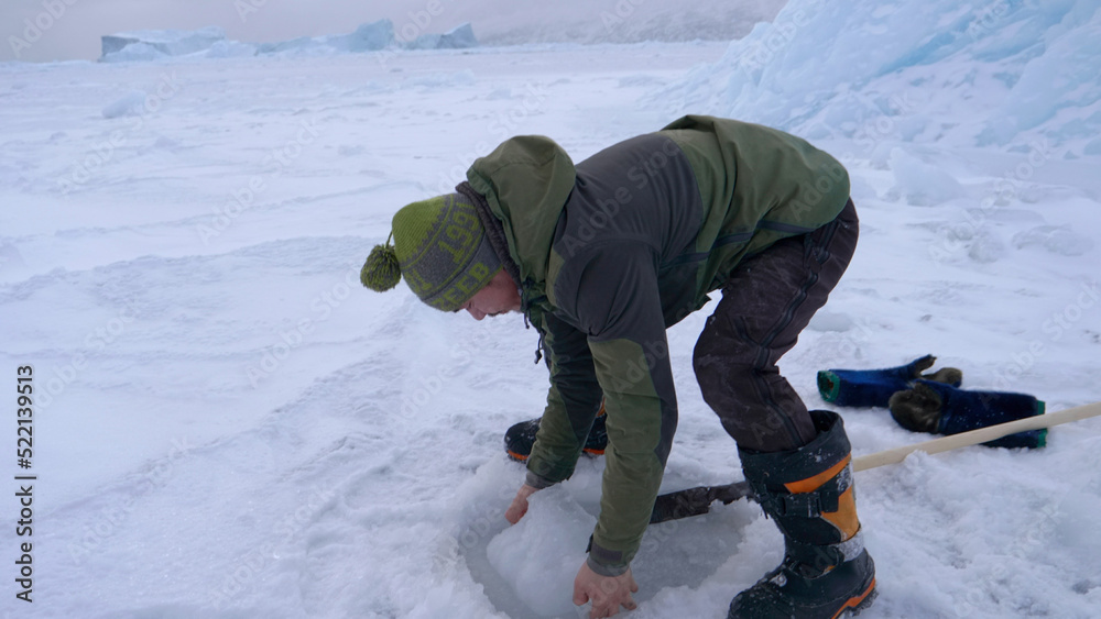 Arctic Greenland sea ice lifestyle: Inuit opens fishing hole ice block ...