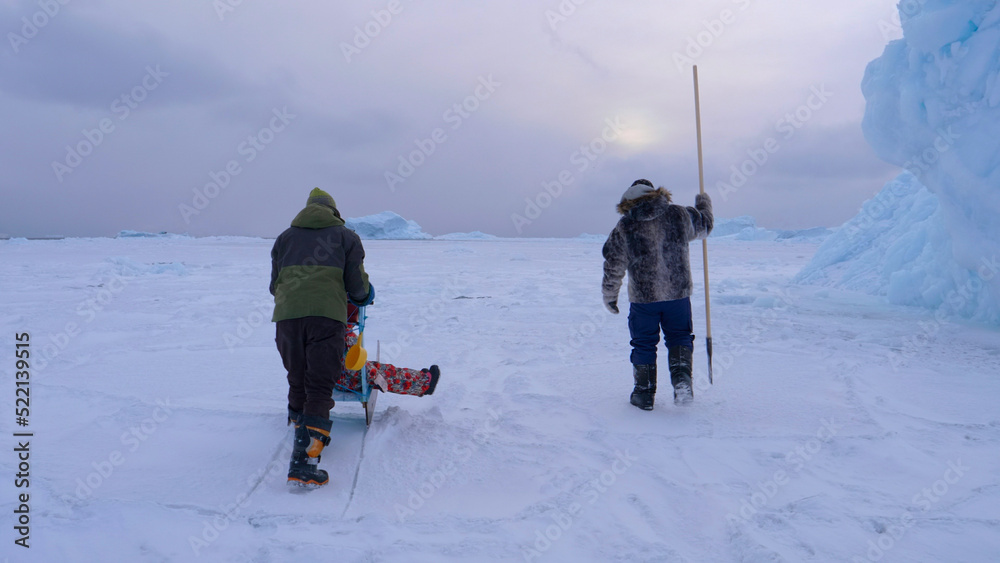 Arctic Greenland sea ice and iceberg: indigenous Inuit on floe, sun ...