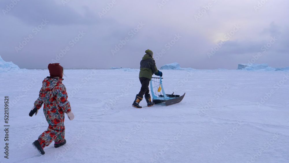 Arctic Greenland indigenous Inuit father, daughter on winter sea ice ...