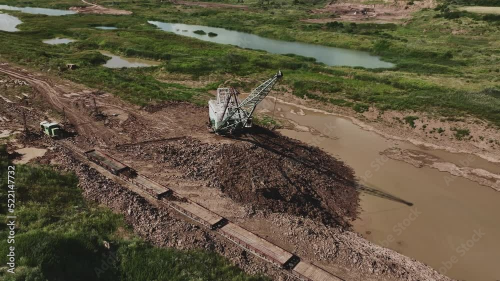 Open-pit mining. Dragline excavator load clay in freight train. Clay ...