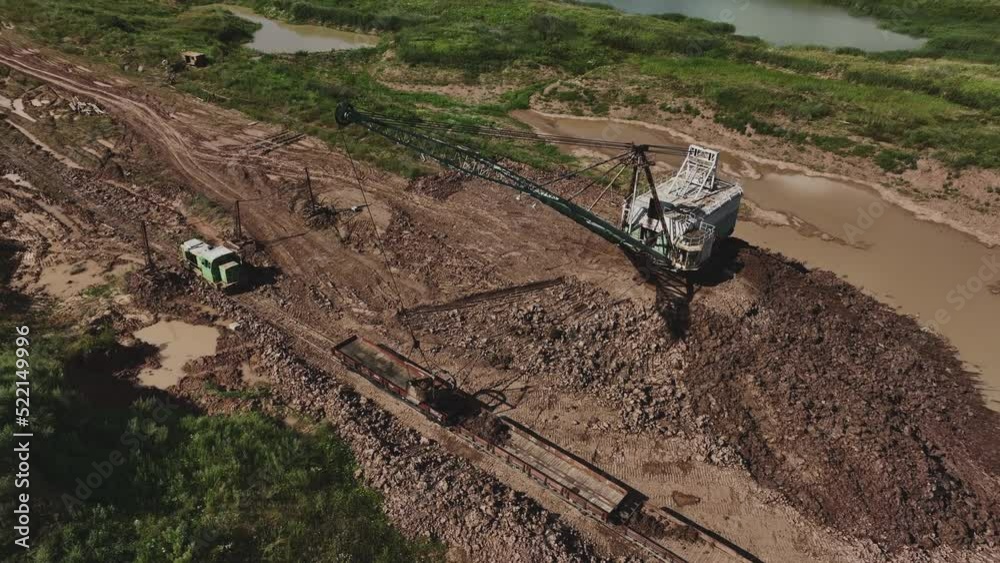Open-pit mining. Dragline excavator load clay in freight train. Clay ...