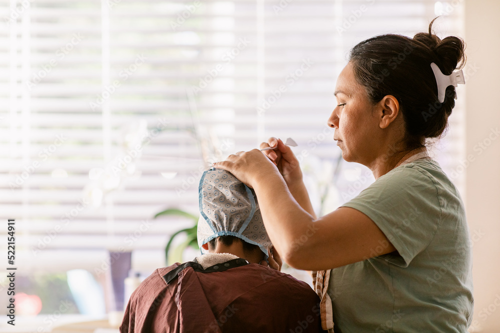 Mother dyeing her teenage son's hair Stock Photo | Adobe Stock