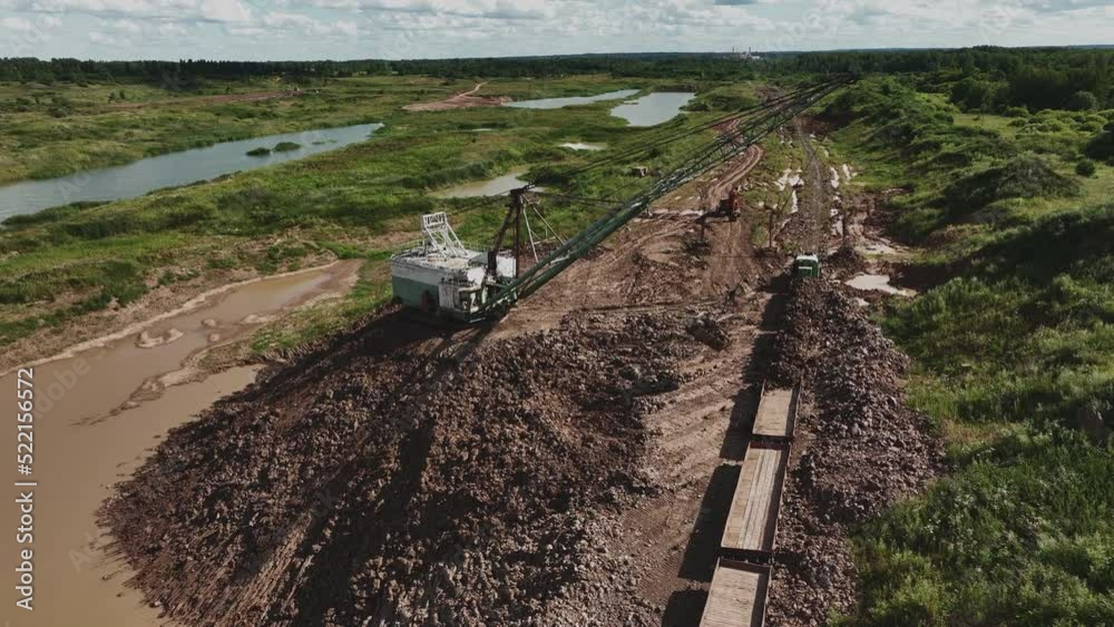Open-pit mining. Dragline excavator load clay in freight train. Clay ...