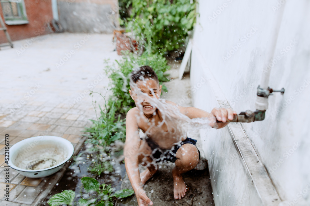 boy splashing water from a faucet Stock Photo | Adobe Stock