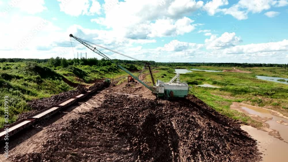 Open-pit mining. Dragline excavator load clay in freight train. Clay ...