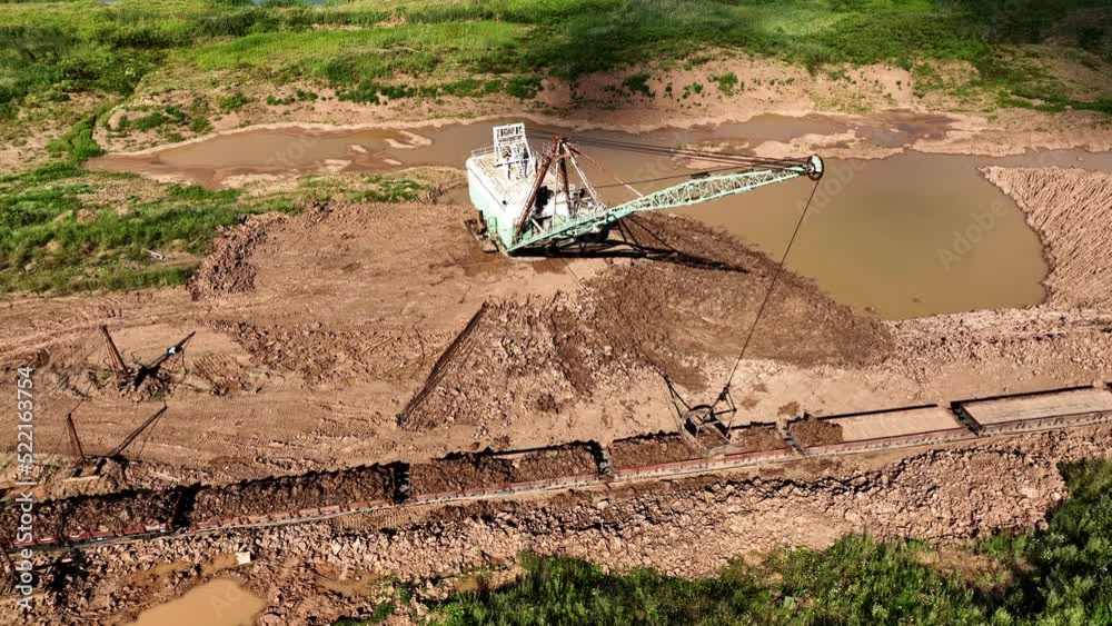 Open-pit mining. Dragline excavator load clay in freight train. Clay ...