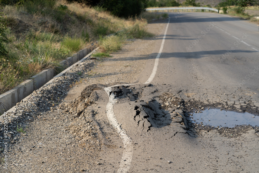 Deep hole in the road. Deformed asphalt surface with potholes melts ...