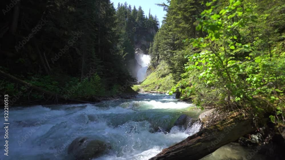 Distance waterfall flowing water over rocks creating fast moving rapids ...