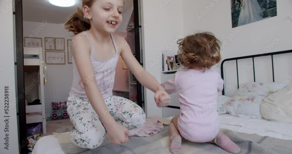 Two little girls are playing at home, jumping for joy and smiling ...