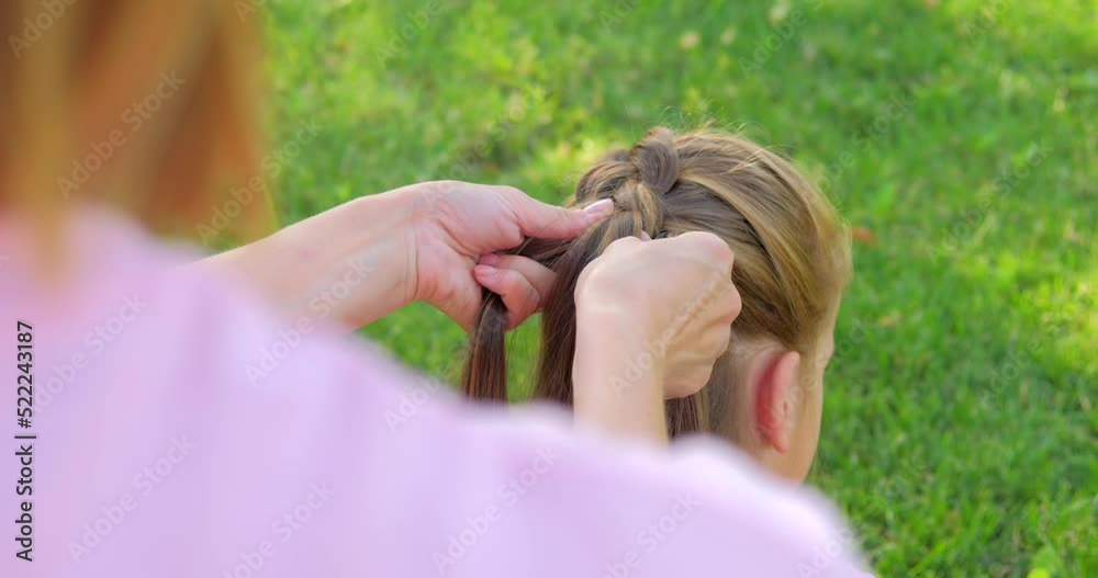 Kindergarten teacher braids a french braid for a girl outdoor Stock ...