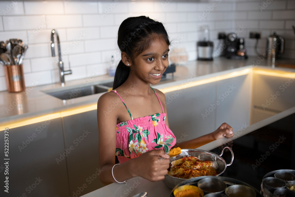 UK, London, Smiling girl cooking in kitchen Stock Photo | Adobe Stock