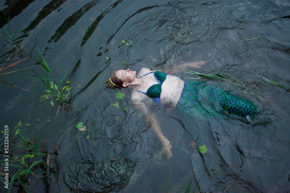 Mermaid story. The little mermaid sits in a boat. Mermaid at sunset ...
