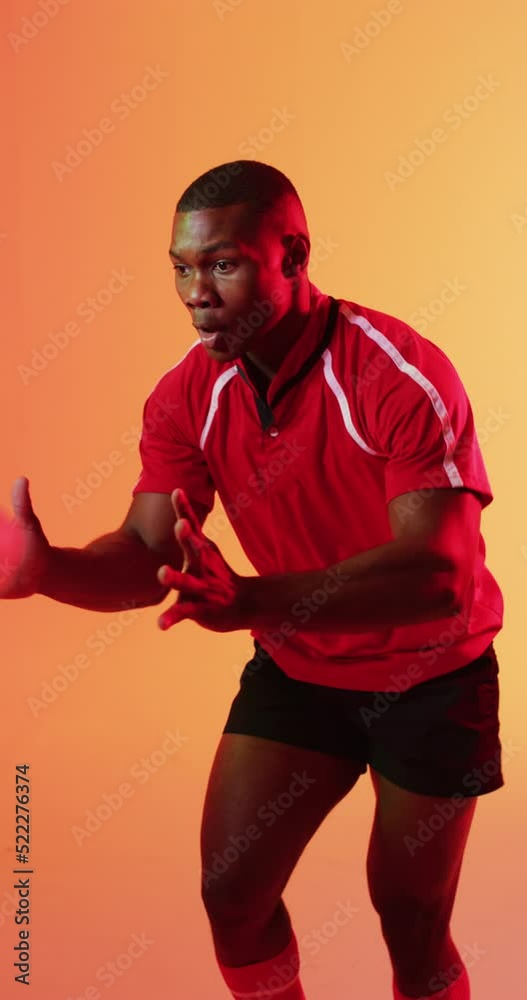 Vertical video of african american male rugby player catching rugby ...