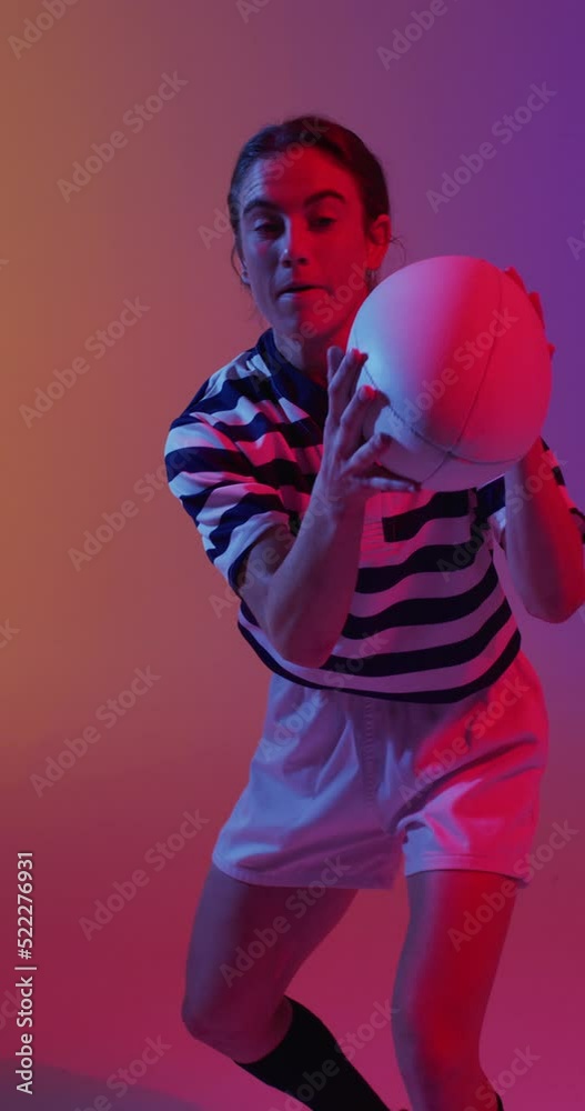 Vertical video of caucasian female rugby player catching rugby ball ...