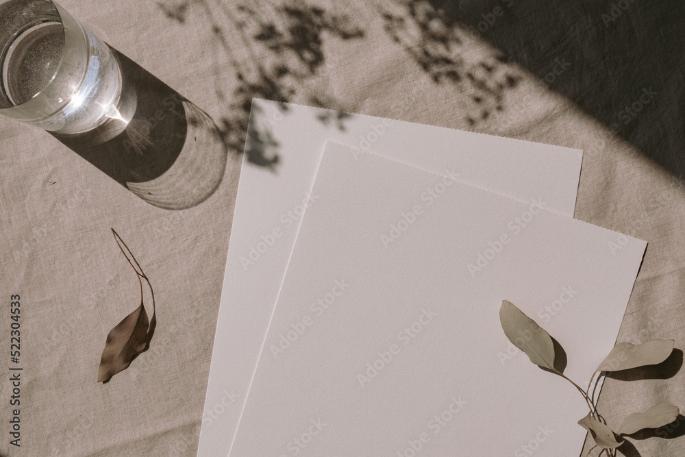 Blank a4 paper mockups with overlay shadows, decorative twigs, glass of ...