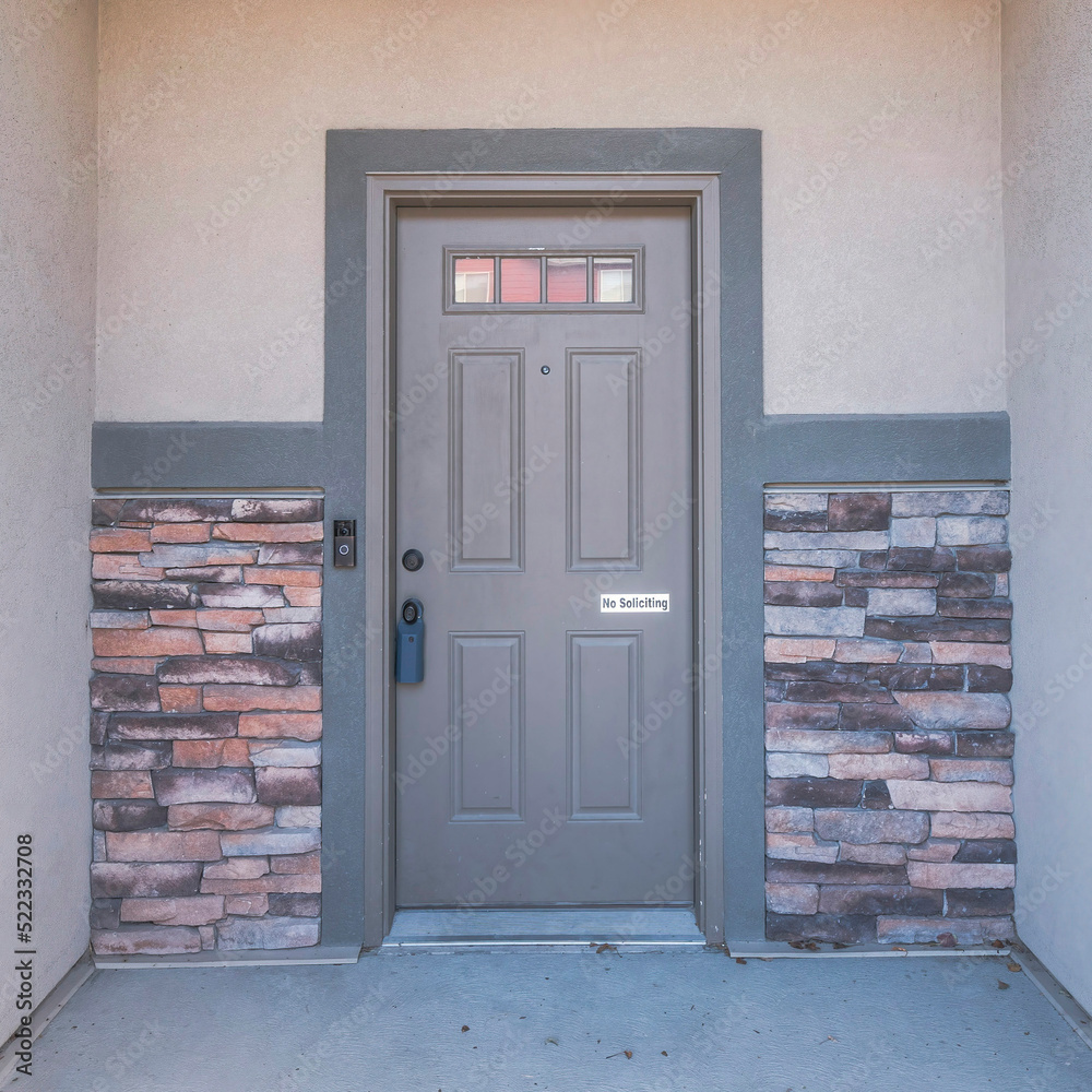 Square Front door exterior with brown stone bricks and concrete ...