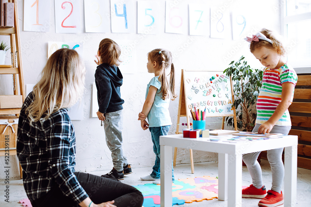 Group of adorable children pupils studying colorful numbers hung on ...