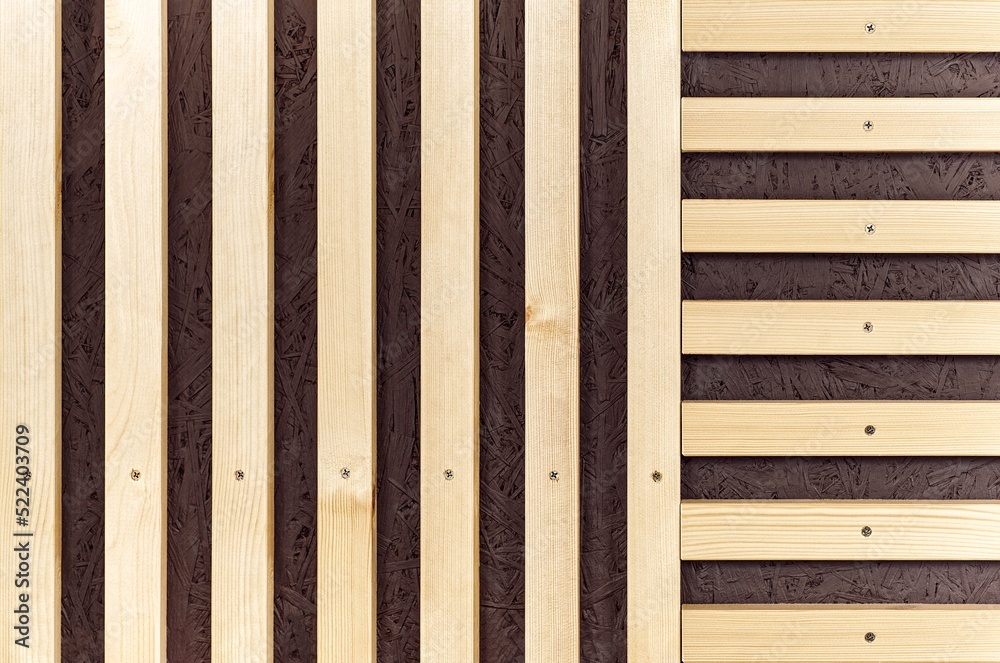 Building wall decorated with stylish wooden slats made of thin light ...