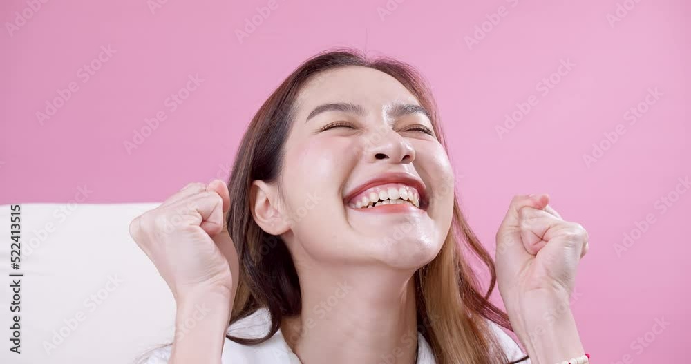 Asian girl shaking hands and posing while sitting on a chair in front ...