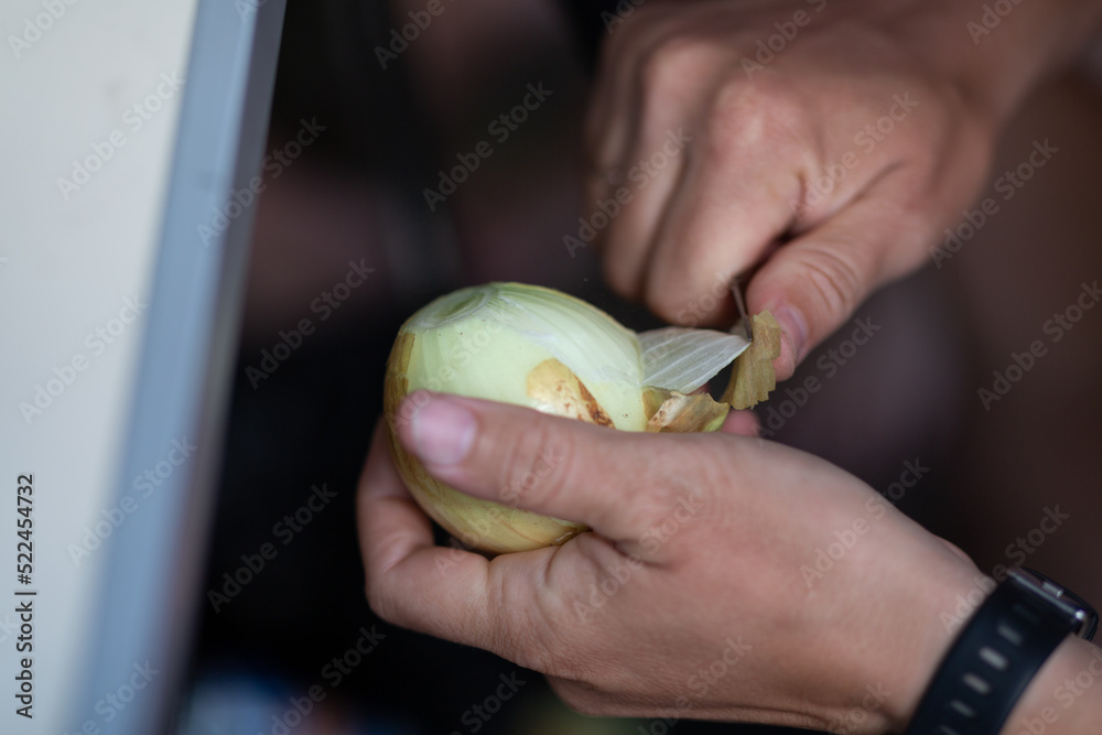 Men's hands close-up clean the onion skin from the hands, preparation ...