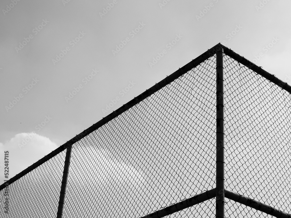 silhouette wire mesh of fence with sky background, black and white ...