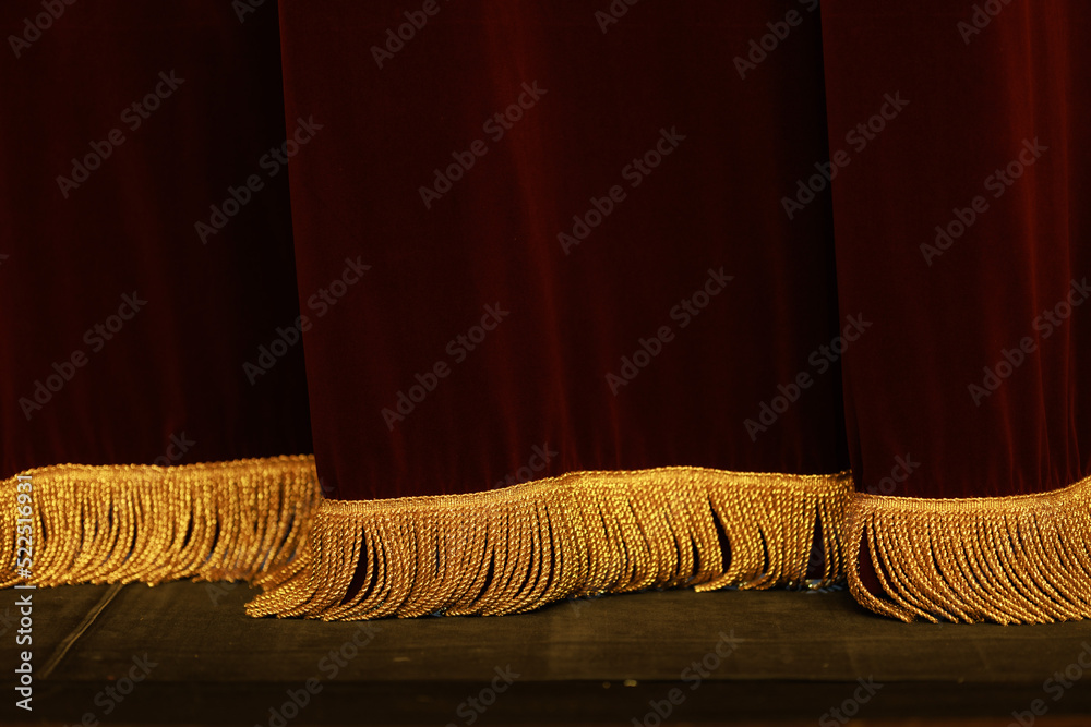 Theatrical dark red velvet curtain with golden fringe. Texture ...