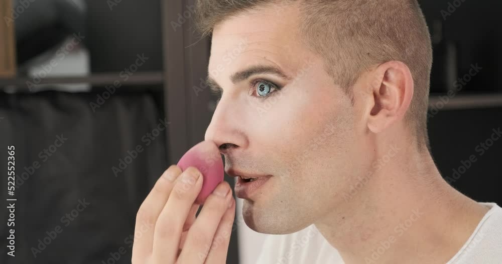 Drag queen artist applying makeup with a sponge while getting ready in ...