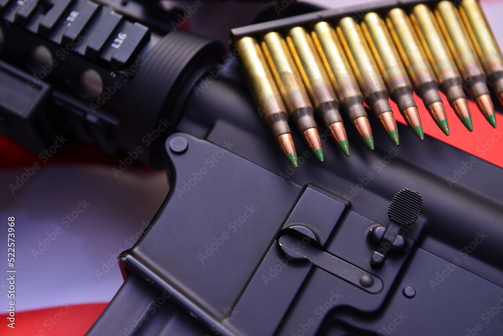 A closeup of an automatic carbine rifle with stacks of ammunition ...