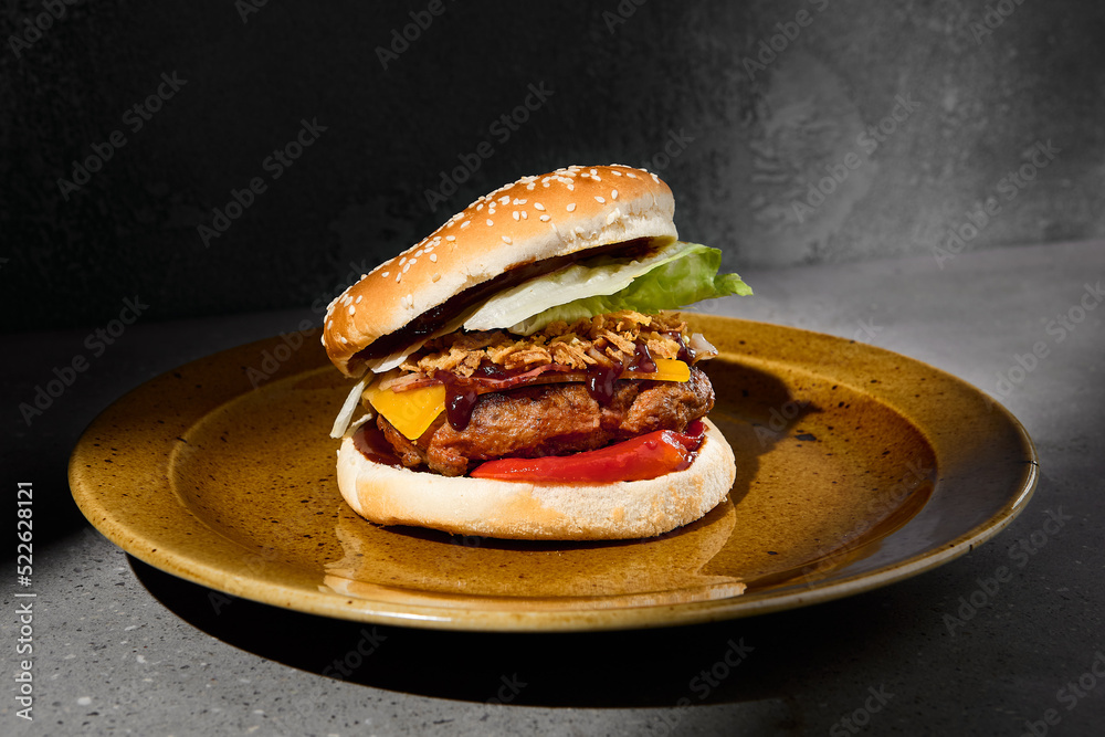 American burger with cheese and crispy onion on plate on gray concrete ...