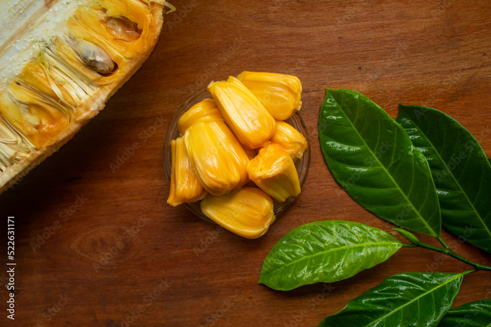 peeled jackfruit with jackfruit leaf background and wood pattern as the ...