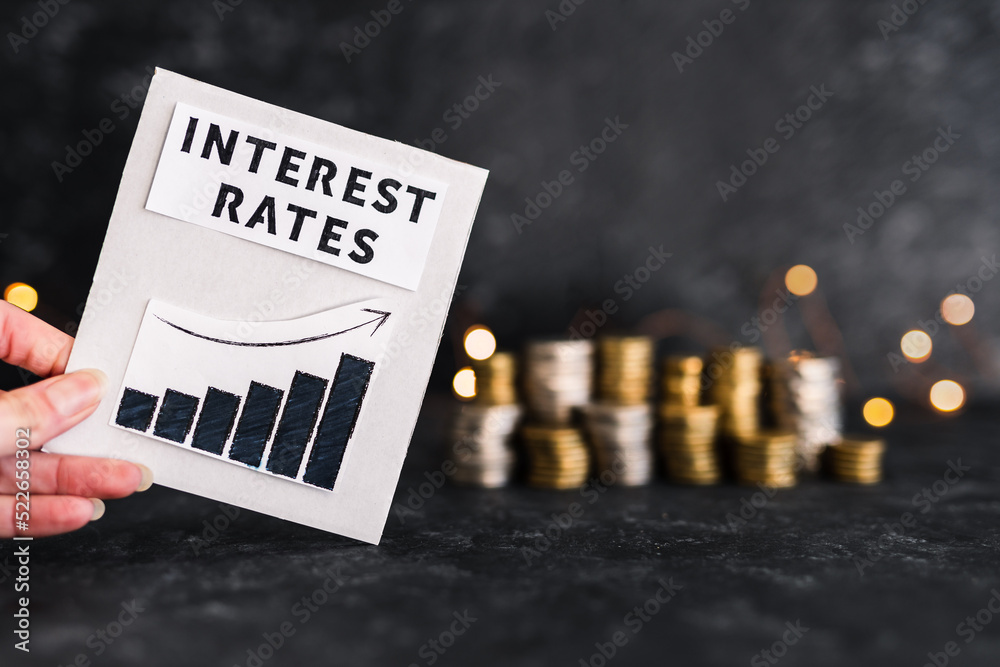 interest rates text and graph showing stats going up in front of stacks ...